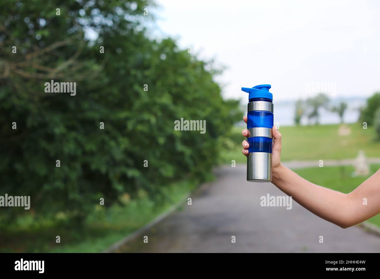 Female hand with bottle of protein shake outdoors Stock Photo - Alamy