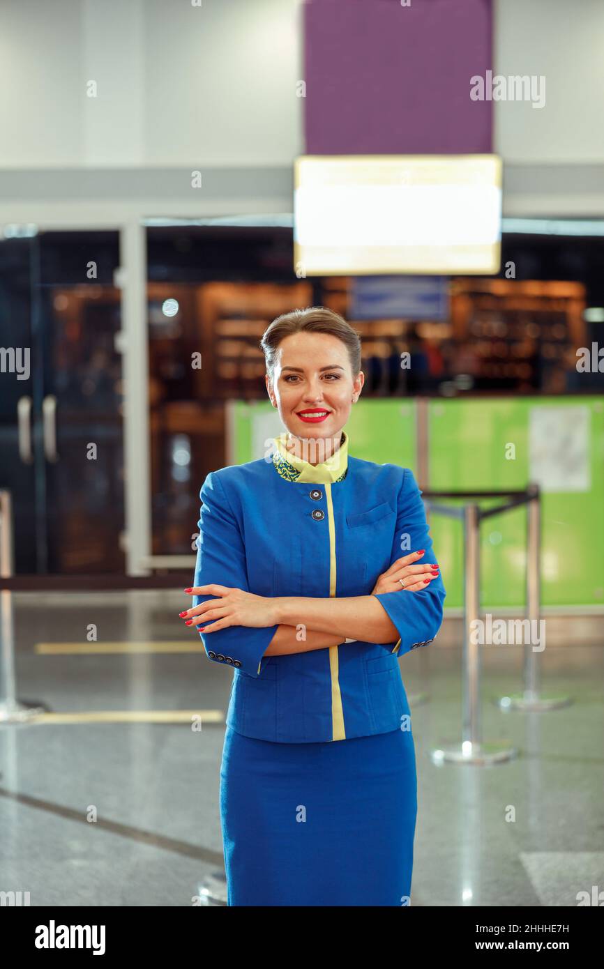 Joyful woman air hostess standing in airport terminal Stock Photo - Alamy