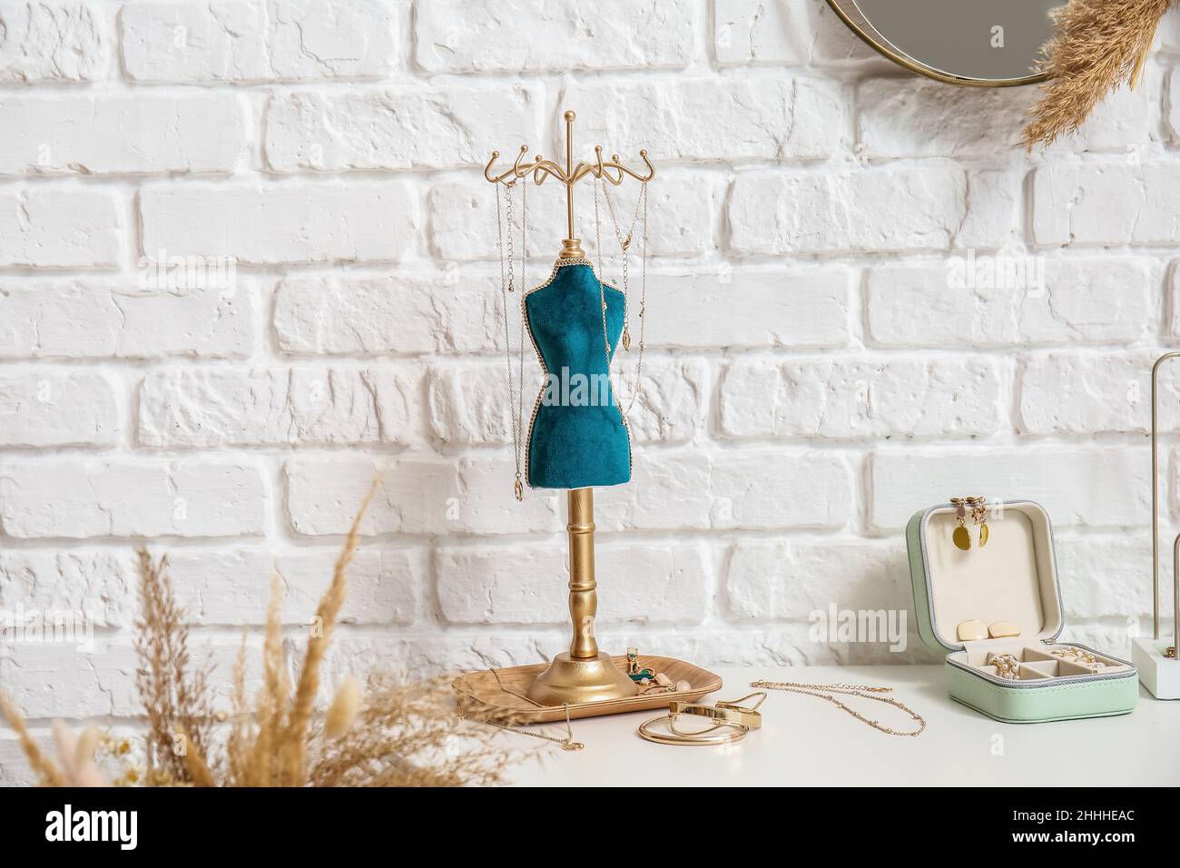 Stand and box with stylish jewelry on table near white brick wall Stock ...