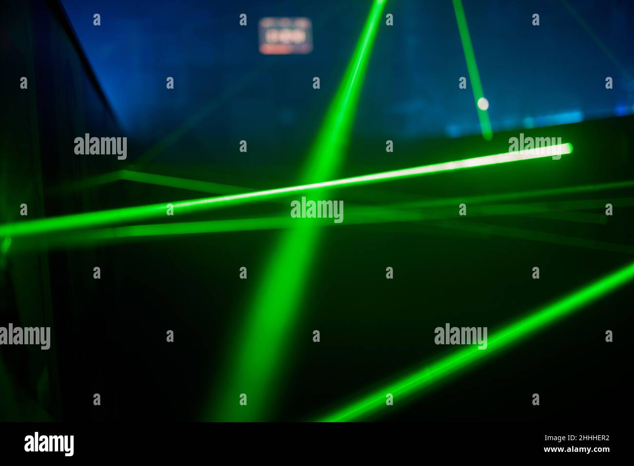 Bright green neon laser lights illuminate the darkness creating lines ...