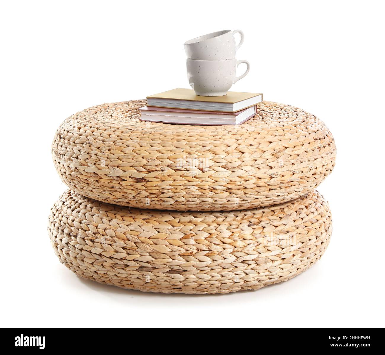 Books and cups on wicker poufs against white background Stock Photo - Alamy