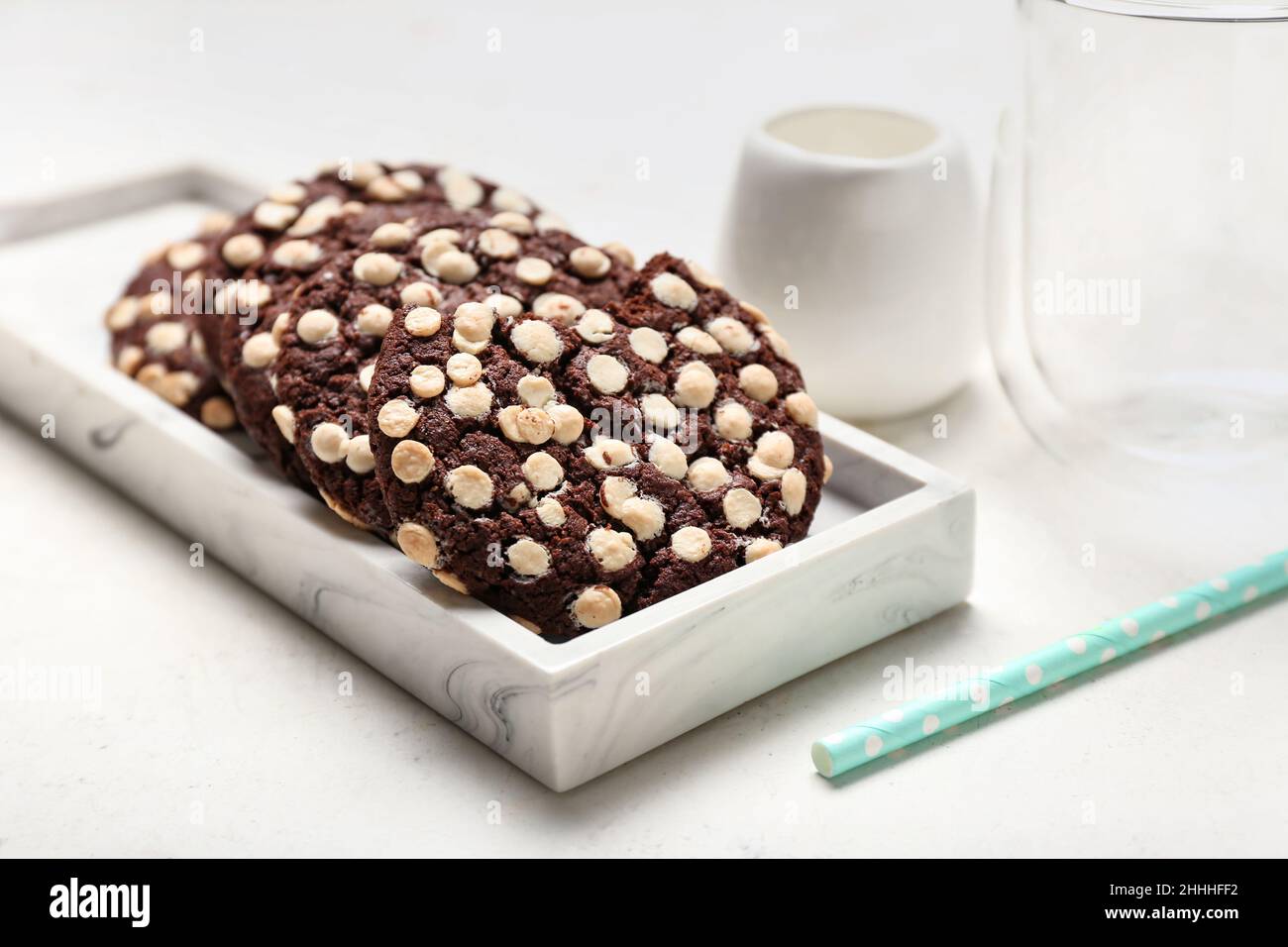 Board of tasty cookies with white chocolate chips on light background ...