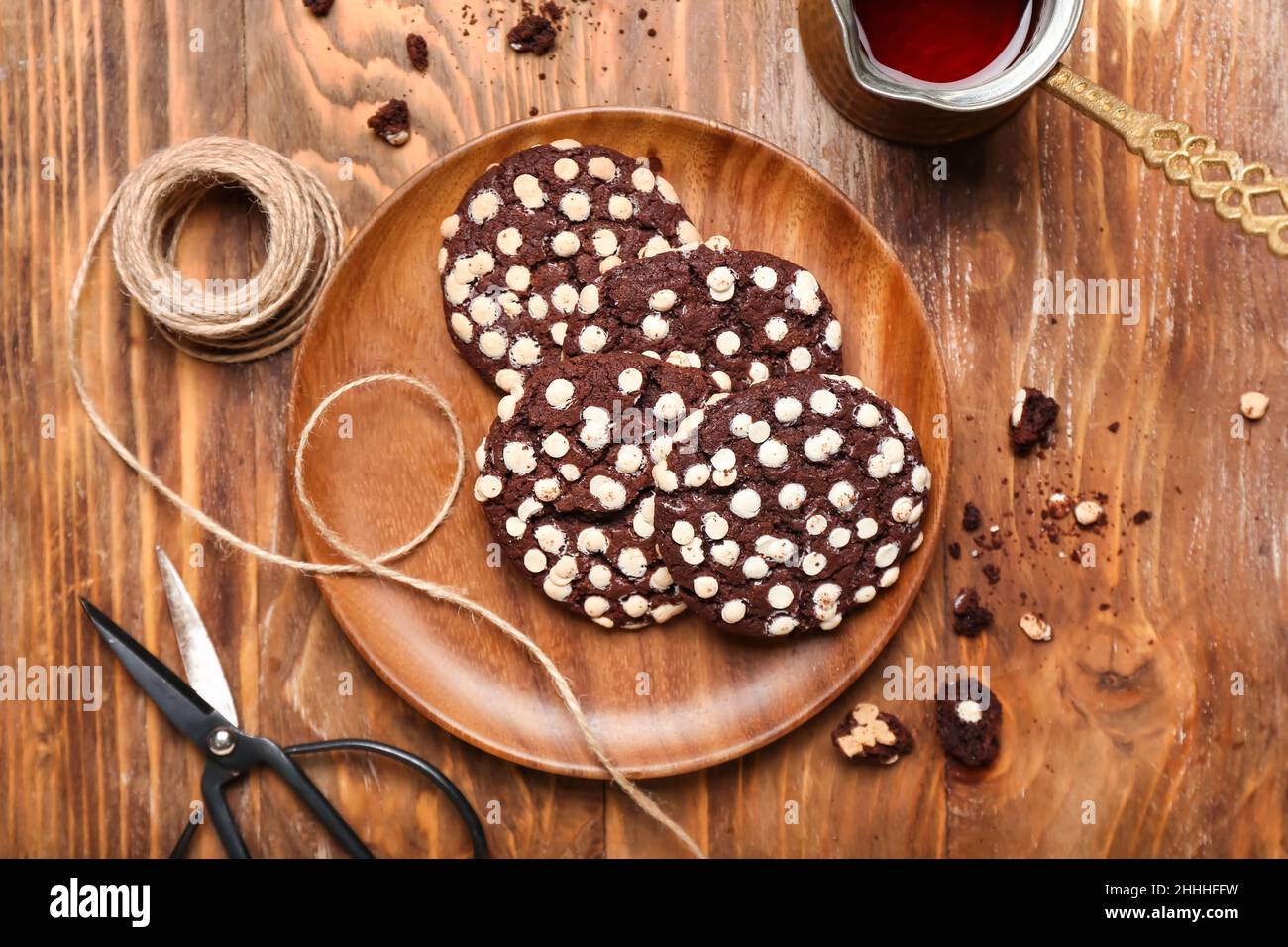Plate of tasty cookies with white chocolate chips, rope and scissors on ...
