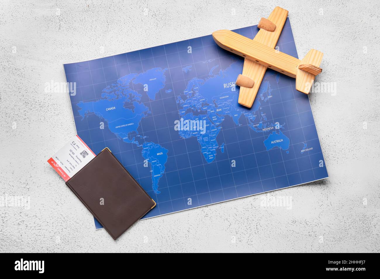 World map, passport with ticket and wooden plane on light background ...