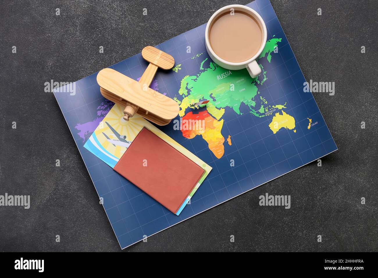 Cup of coffee, wooden plane, passport with ticket and map on dark ...