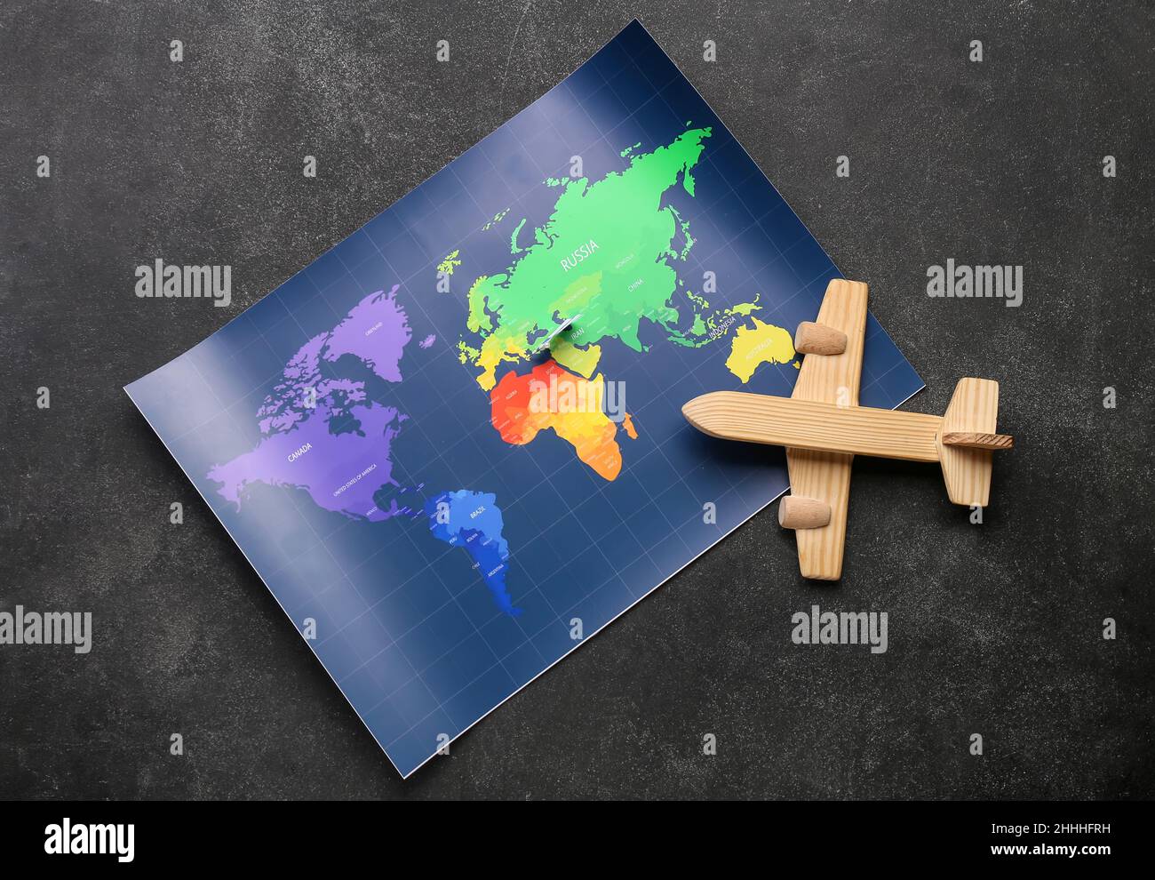 Wooden plane and world map on dark background Stock Photo - Alamy