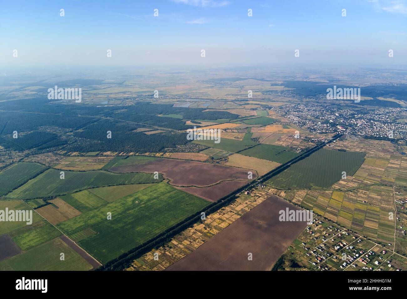 Aerial view of farm fields and distant scattered houses in rural area ...