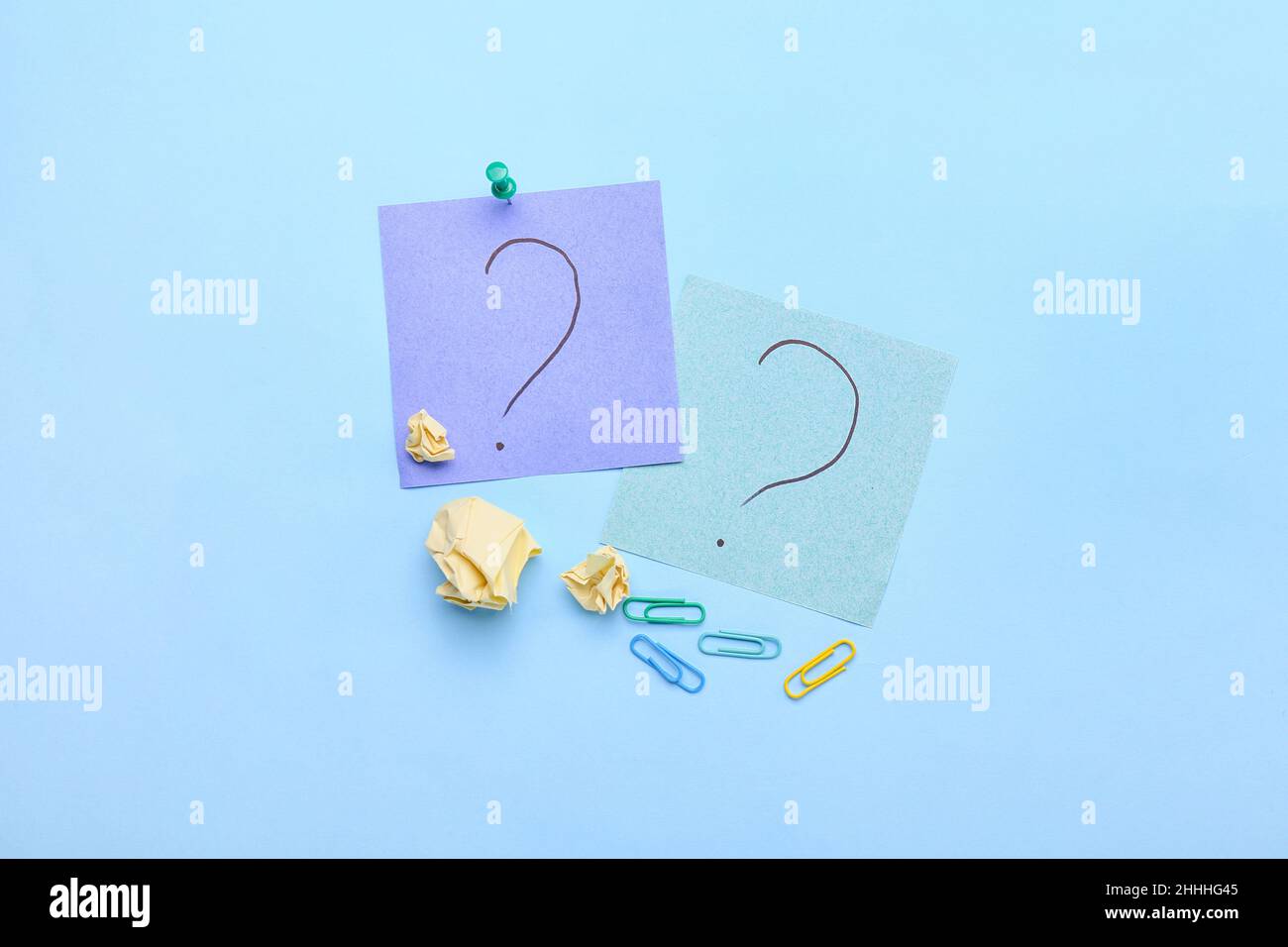 Paper sticks with question marks and clips on blue background Stock ...