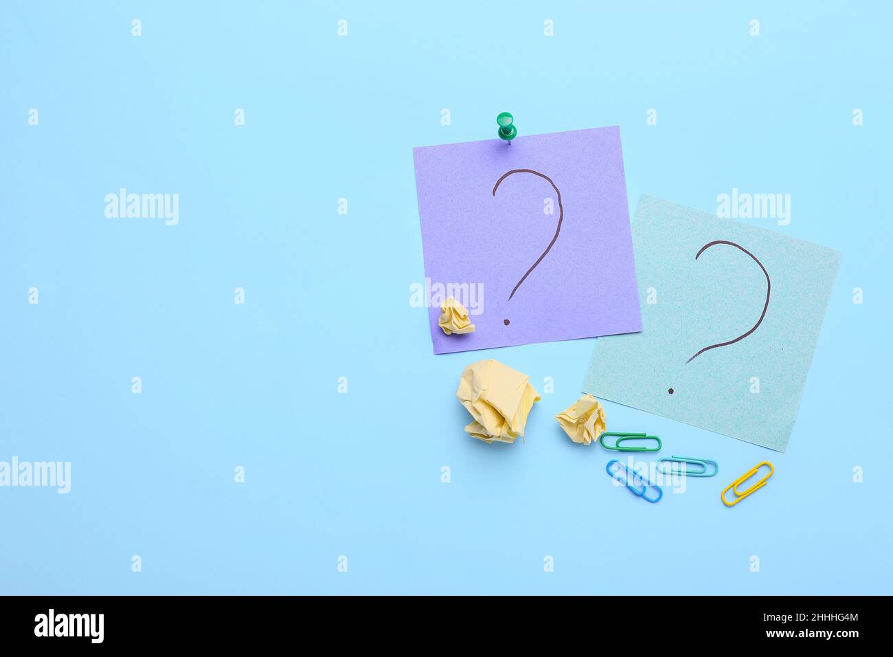 Paper sticks with question marks and clips on blue background Stock ...
