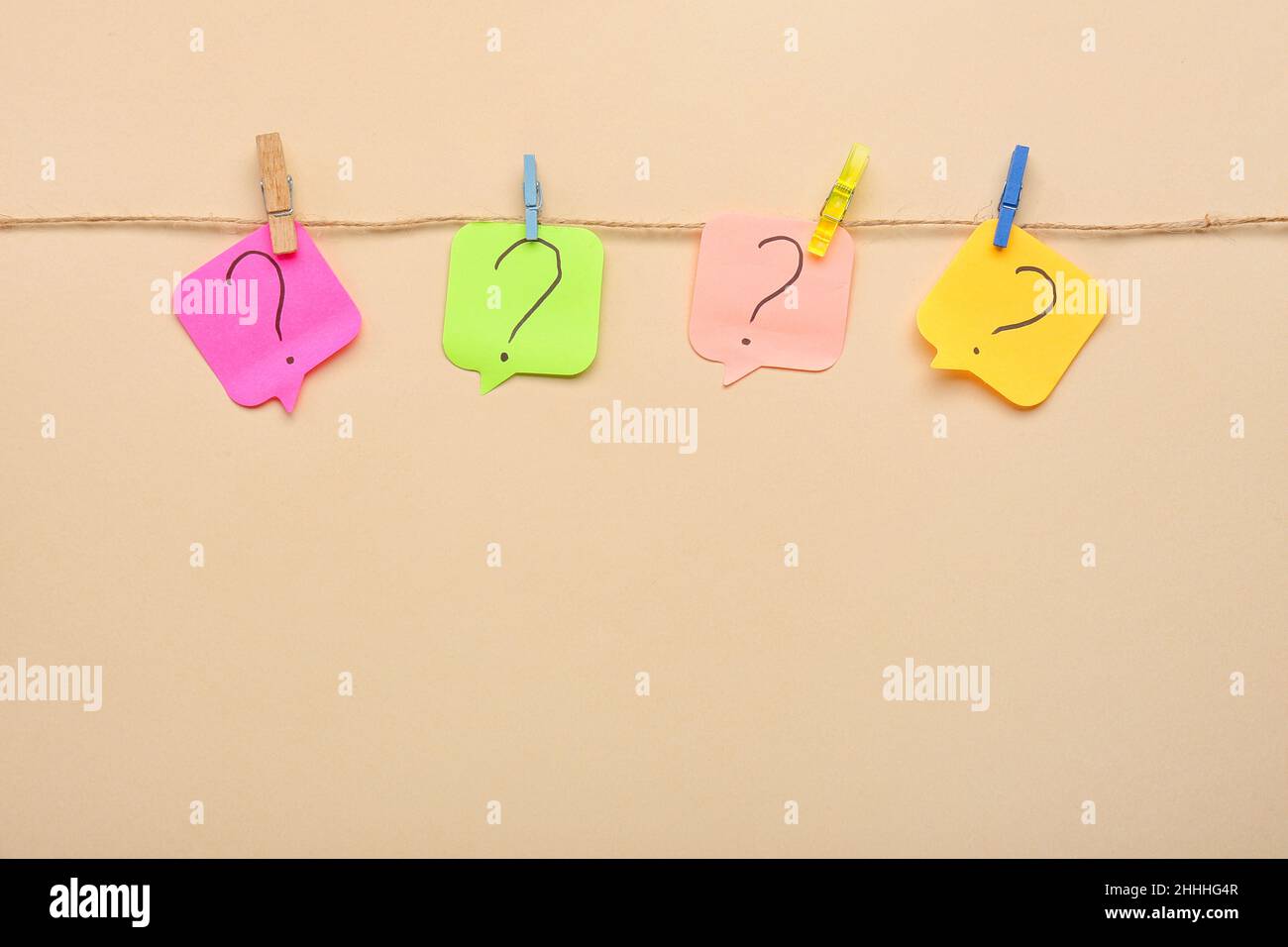 Paper sticks with question marks on rope on beige background Stock ...