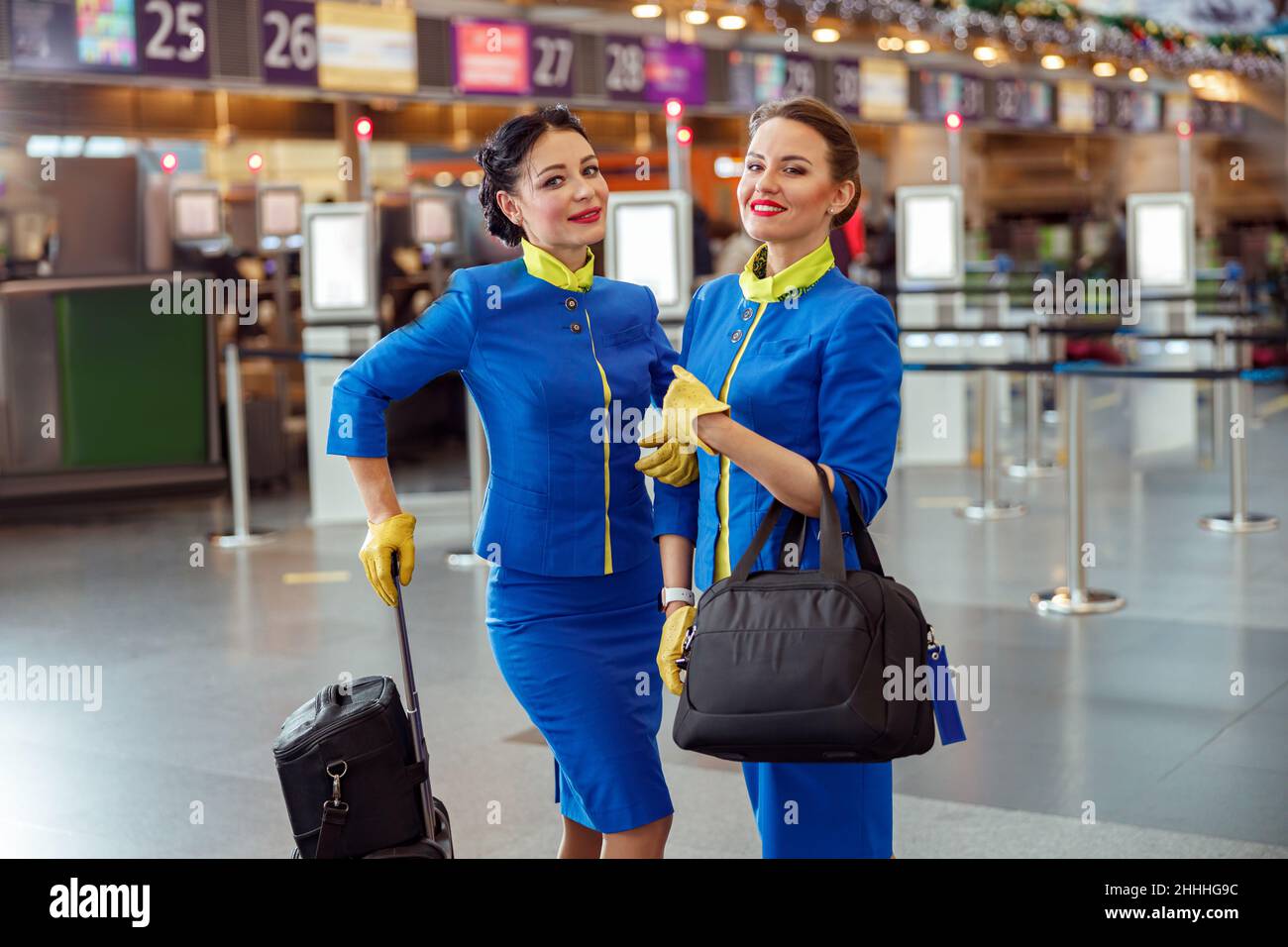 Joyful women flight attendants standing in airport terminal Stock Photo ...