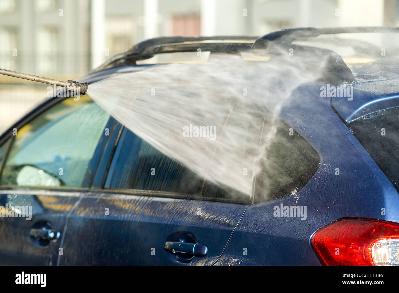 Closeup of male driver washing his car with contactless high pressure ...