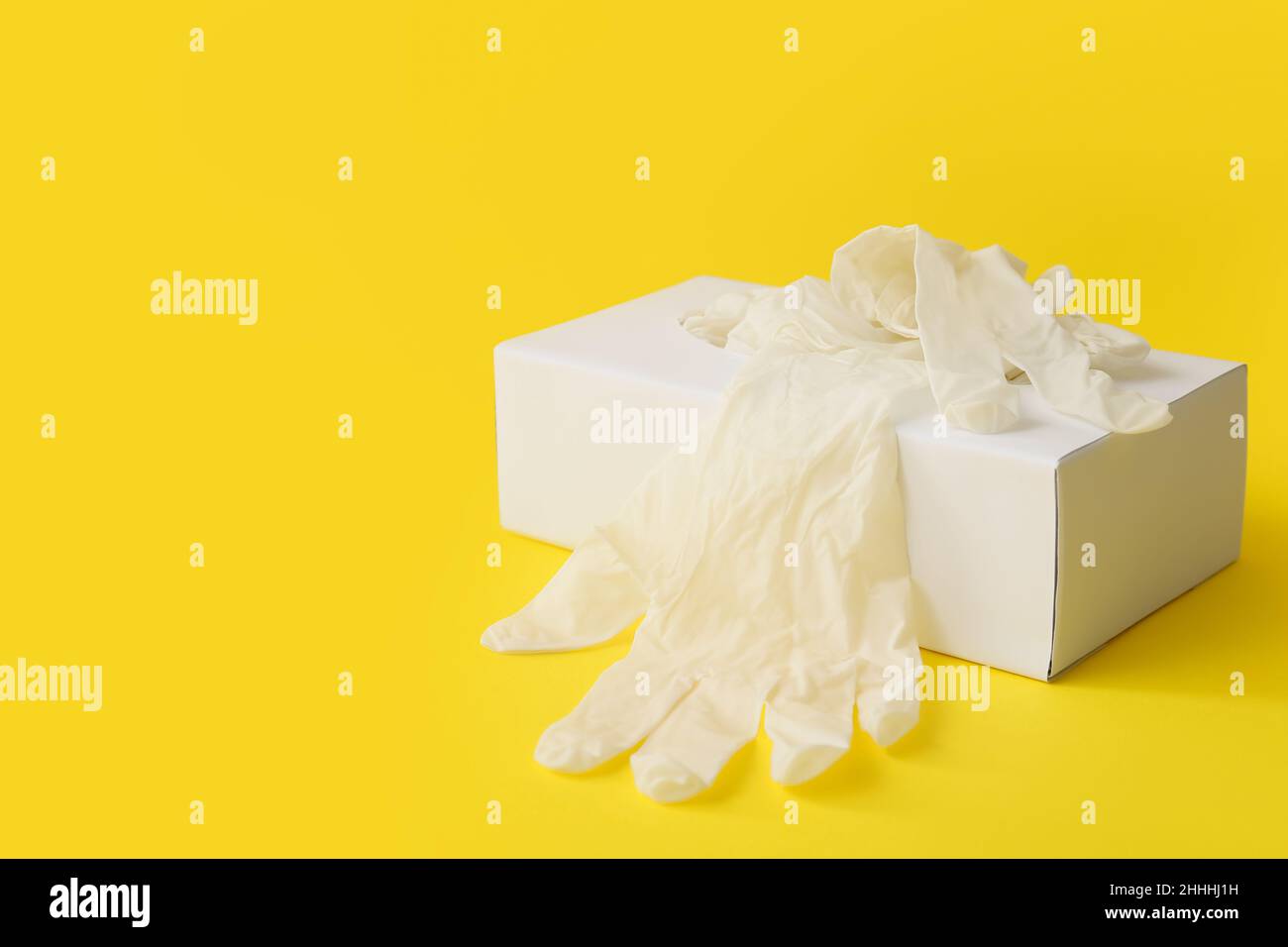 Paper box with white medical gloves on yellow background Stock Photo ...