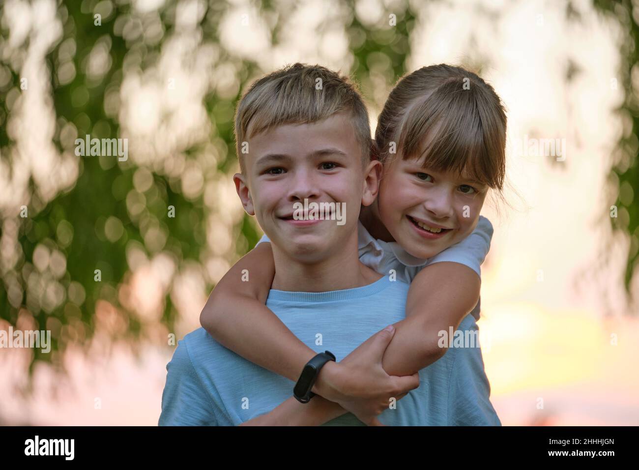 Happy siblings hugging lovingly in summer park. Young children brother ...