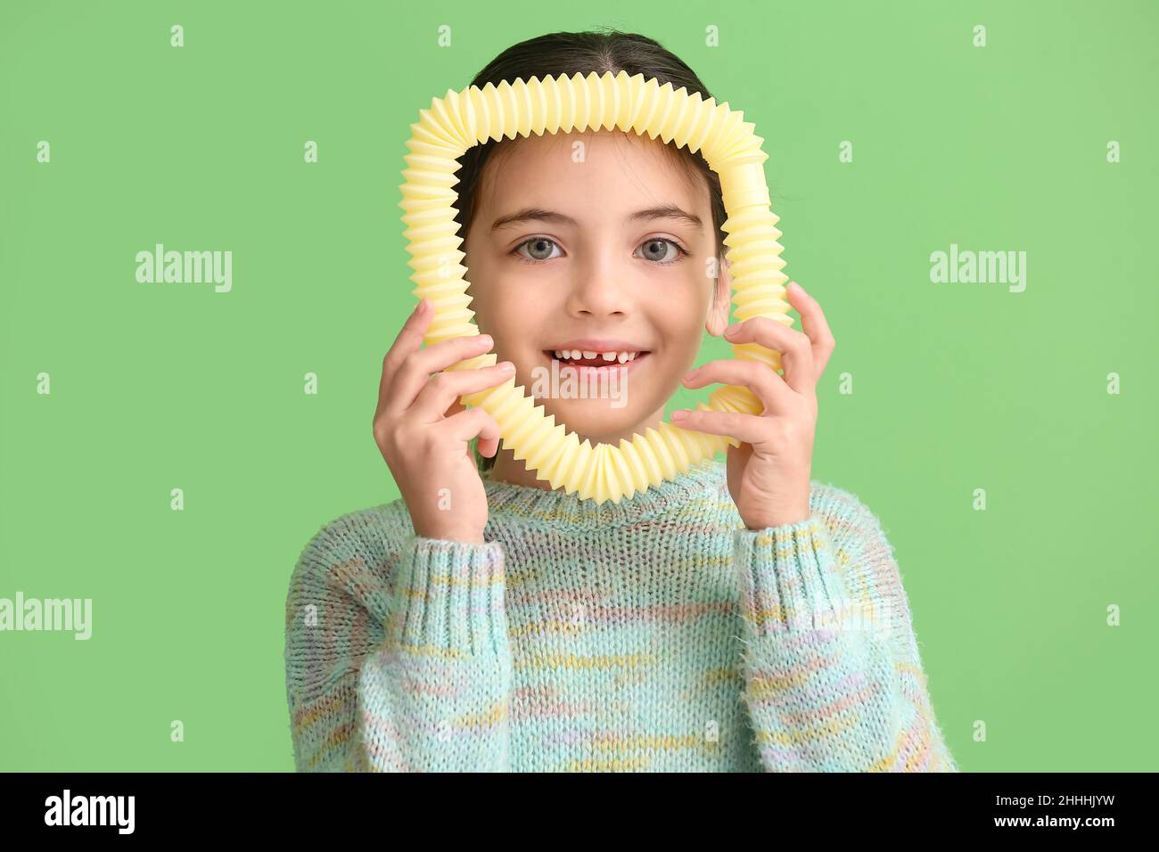 Funny little girl with yellow Pop Tube on green background Stock Photo ...
