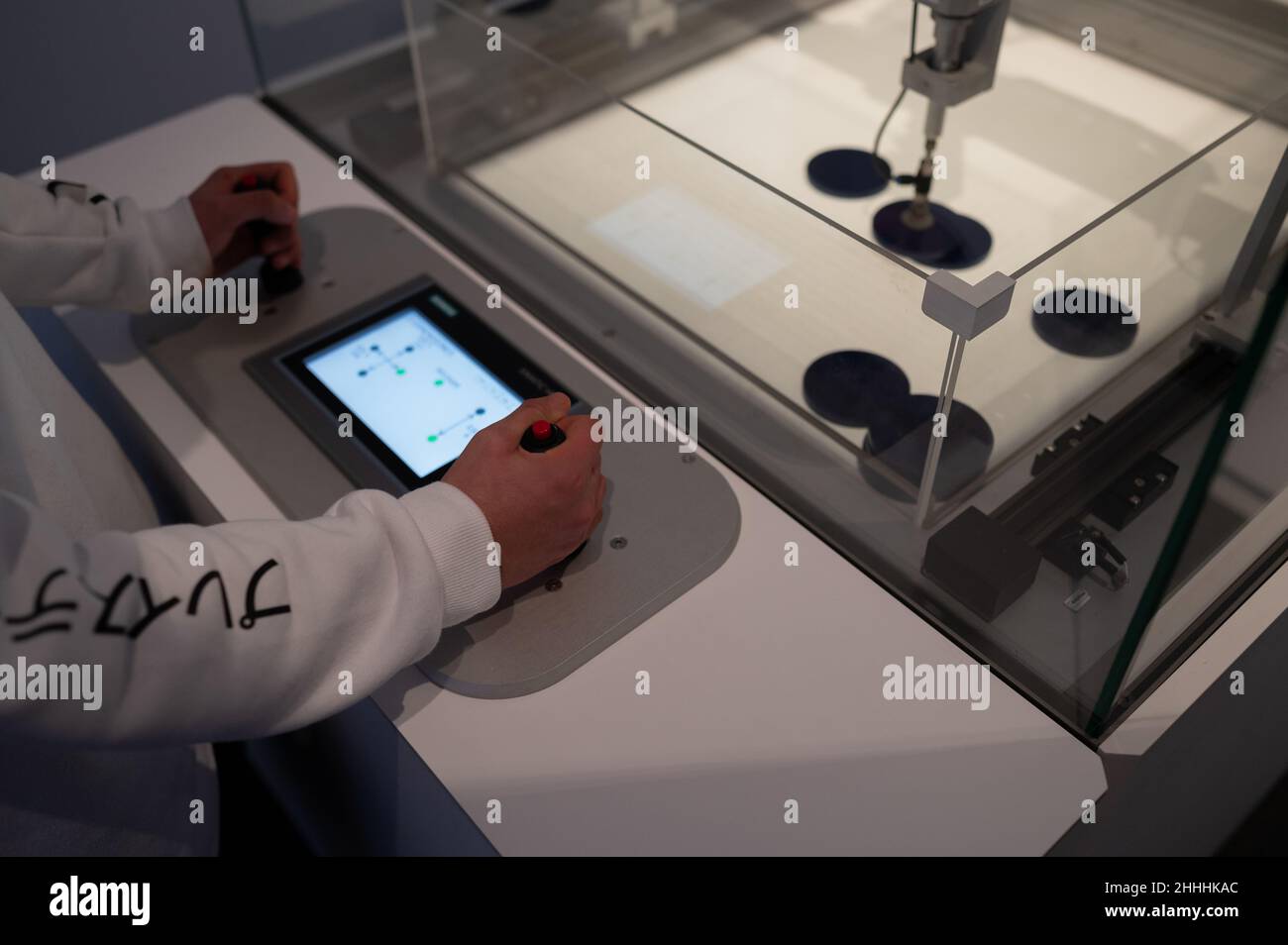 Kids using a machine for controlling objects and learn about dimensions ...