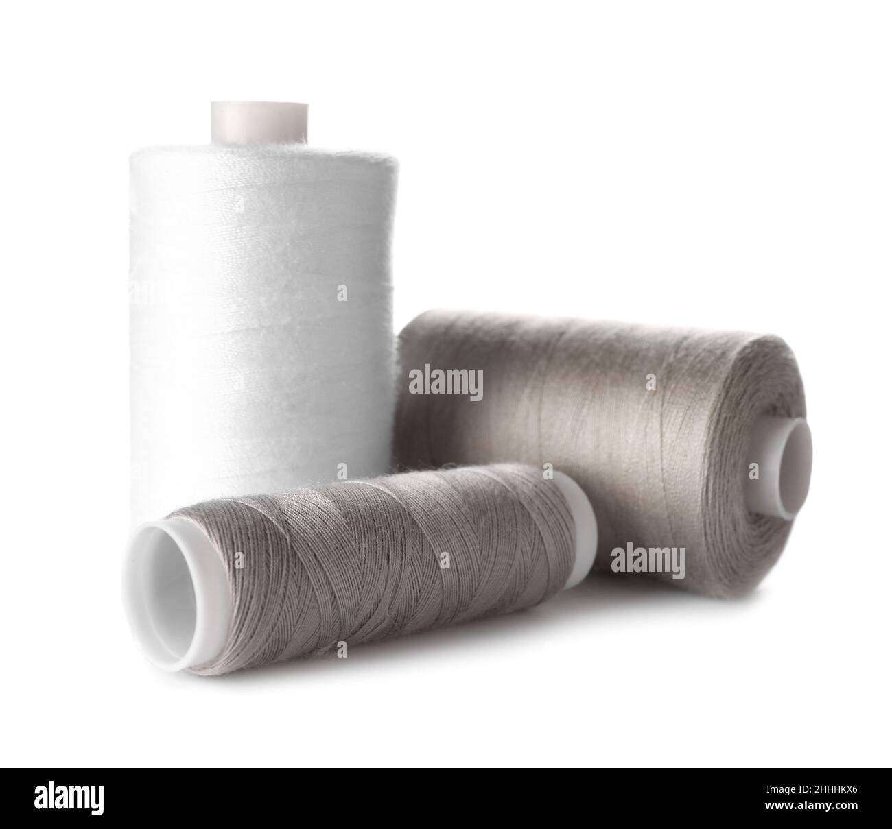 White and grey sewing thread spools on white background Stock Photo - Alamy