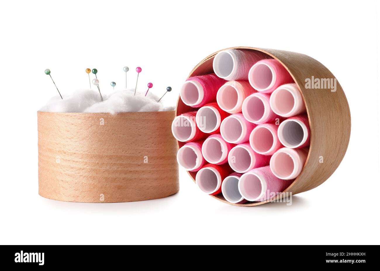 Wooden boxes with sewing thread spools and pins on white background ...