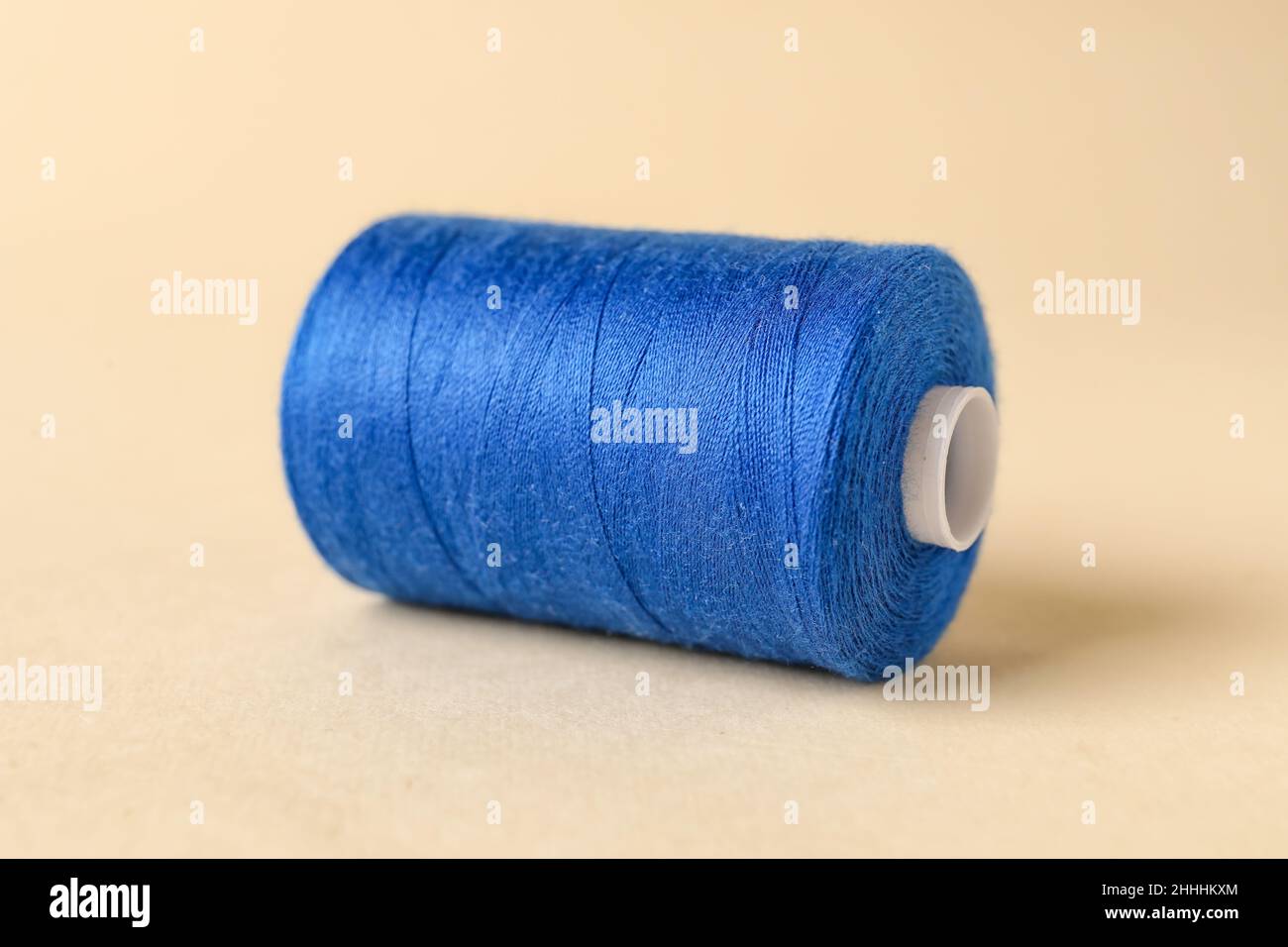 Blue sewing thread spool on light background Stock Photo - Alamy
