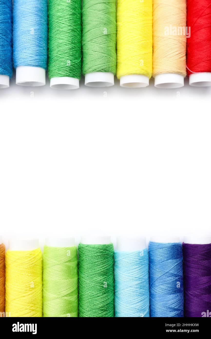 Multicolored sewing thread spools on white background Stock Photo - Alamy