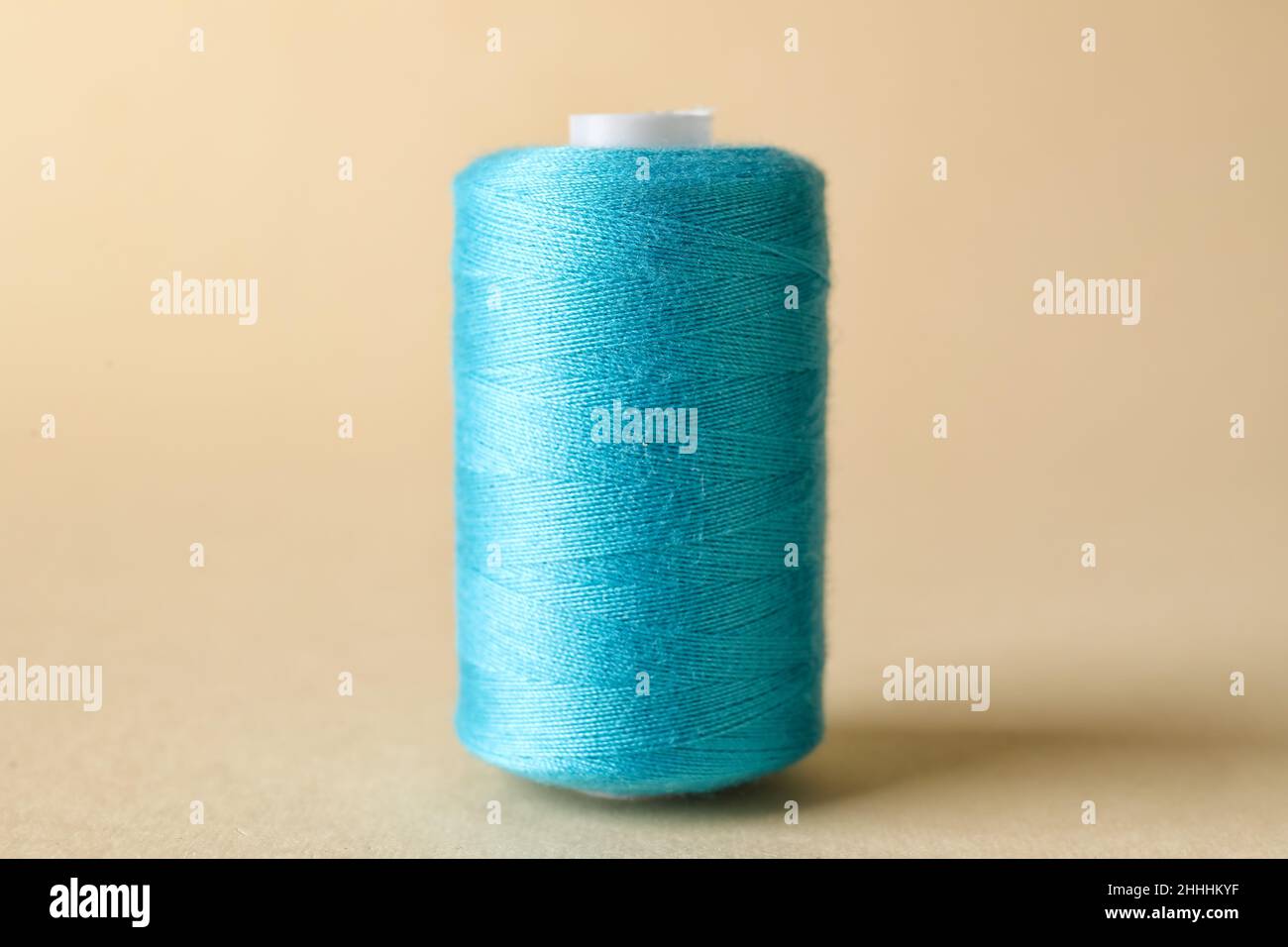 Blue sewing thread spool on light background Stock Photo - Alamy