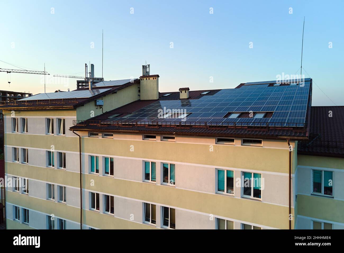 Blue photovoltaic solar panels mounted on industrial building roof for ...
