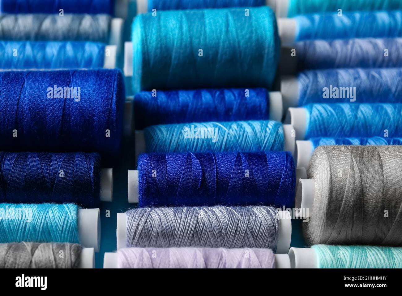 Spools with grey and blue sewing threads, closeup Stock Photo - Alamy