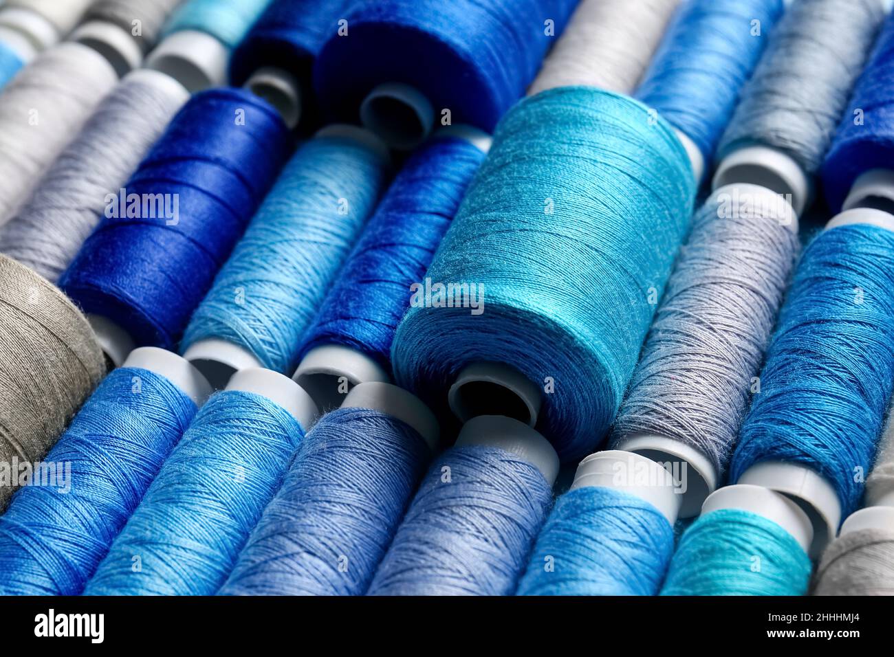 Closeup view of spools with grey and blue sewing threads Stock Photo ...