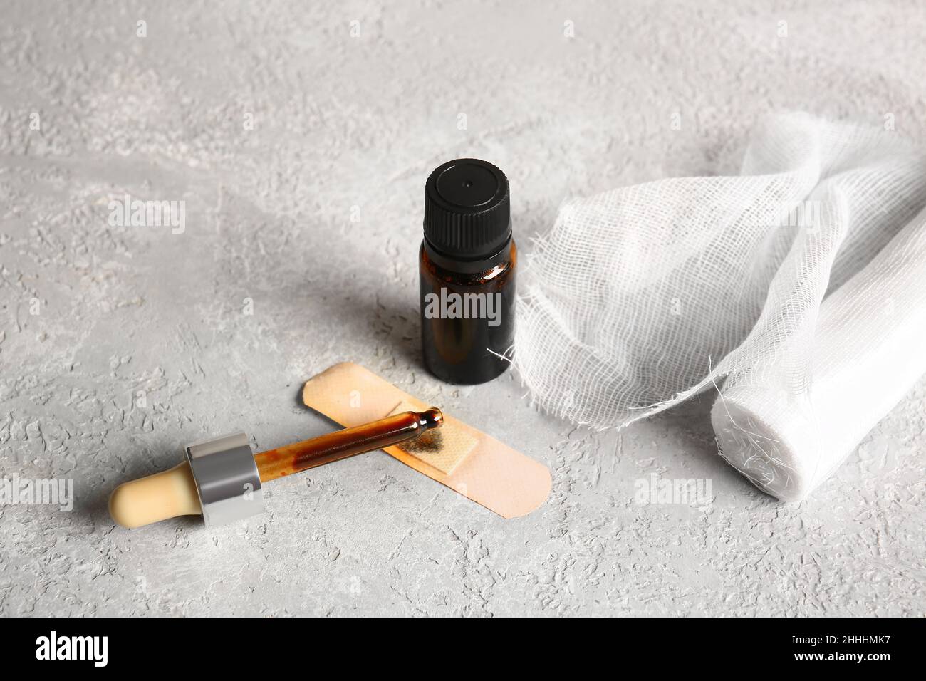 Bottle with iodine, pipette, medical plaster and gauze roll on grunge ...