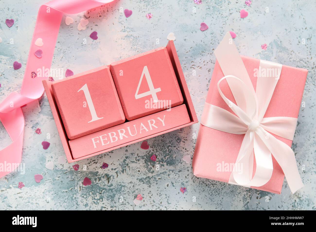 Calendar with date of Valentines Day and gift box on blue background ...
