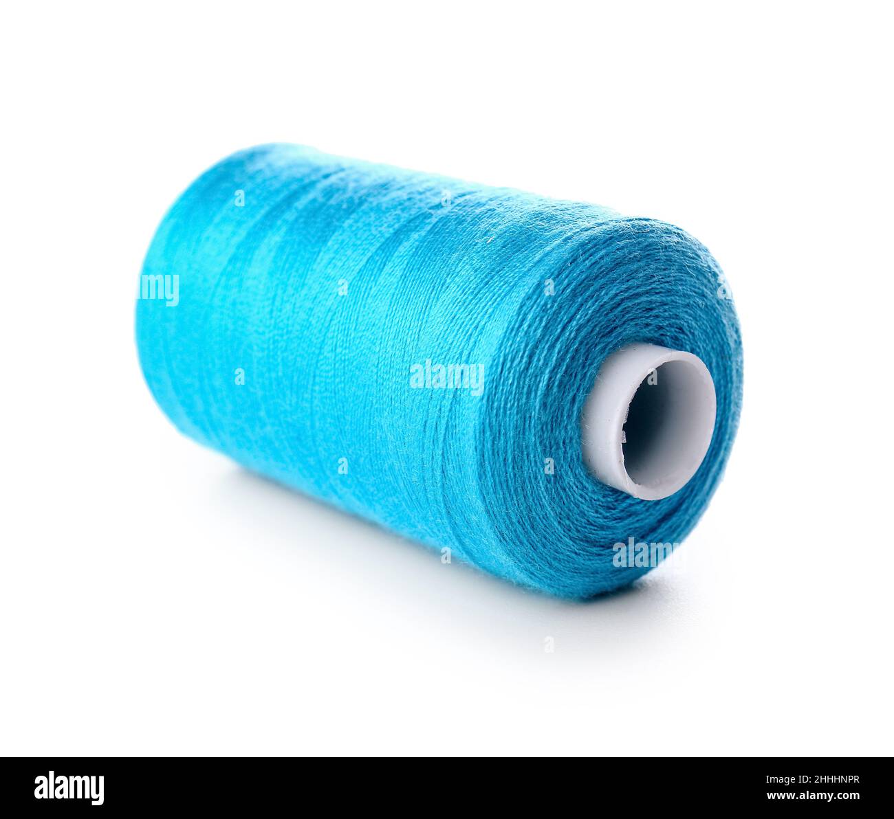 Blue sewing thread spool on white background Stock Photo - Alamy