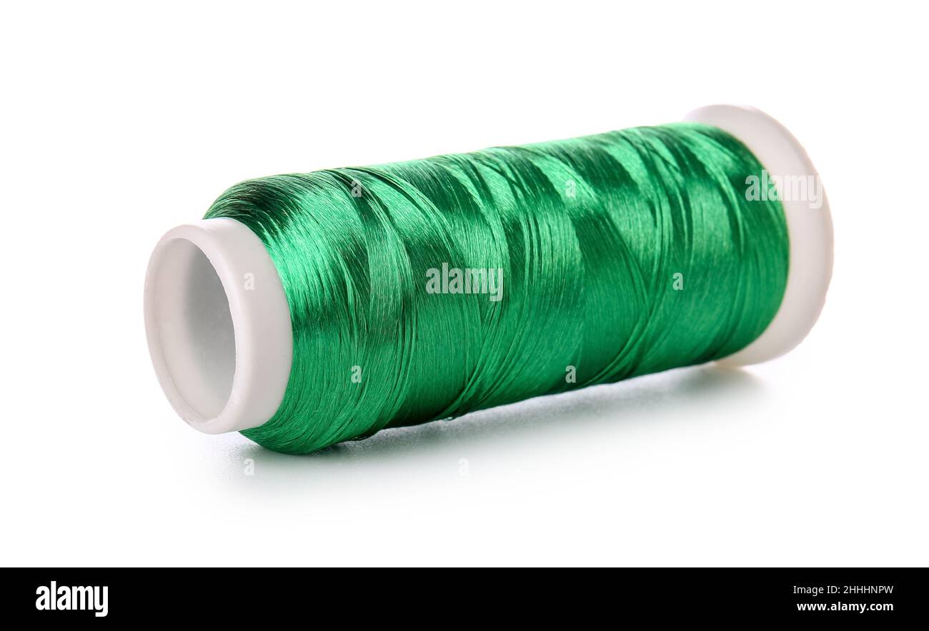 Green sewing thread spool on white background Stock Photo - Alamy