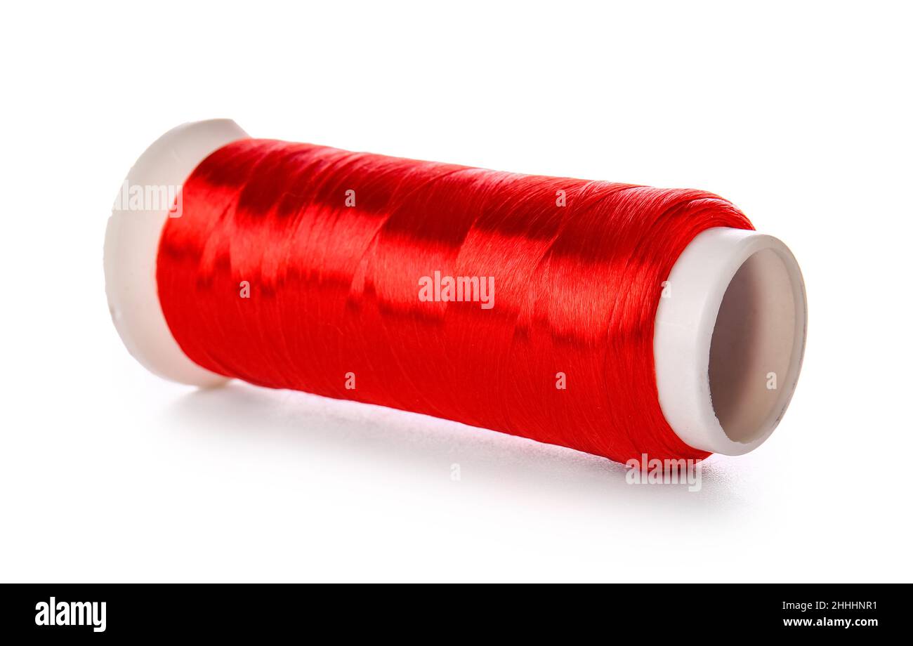 Red sewing thread spool on white background Stock Photo - Alamy