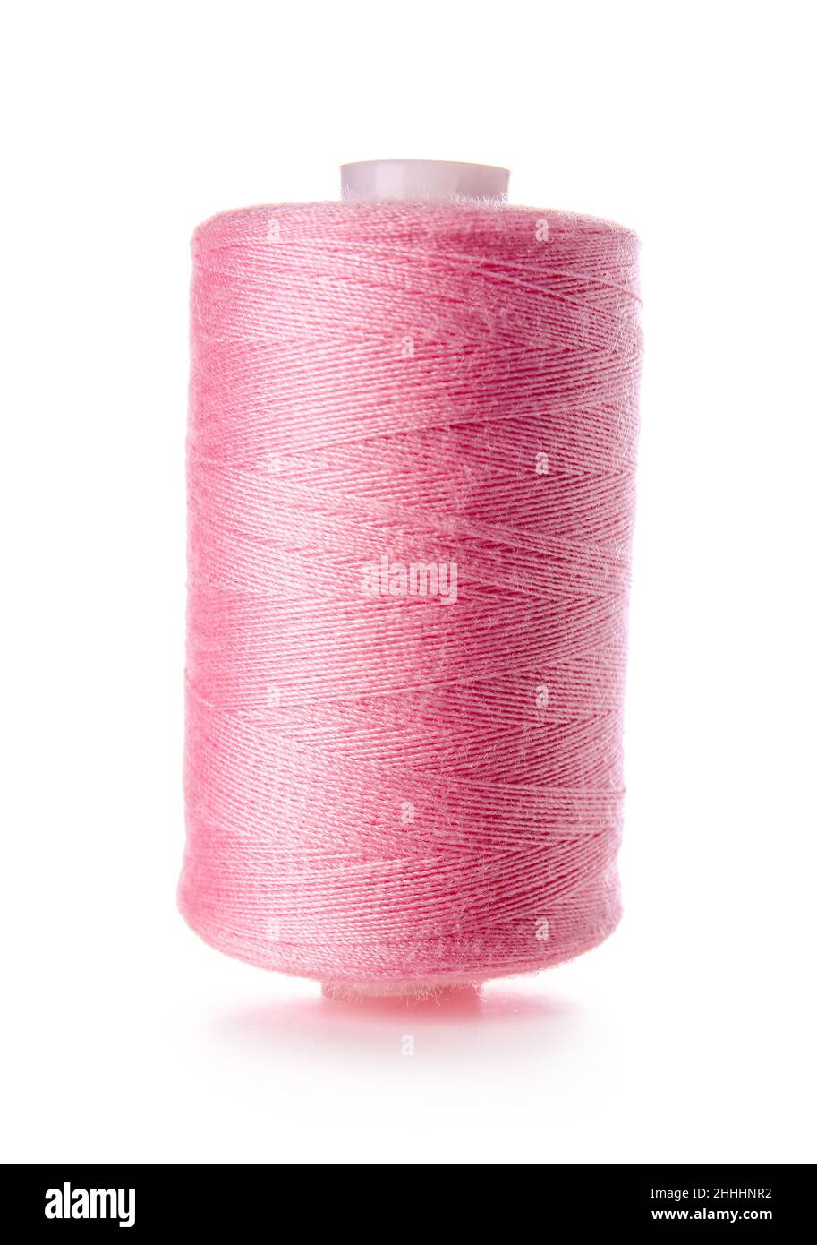 Pink sewing thread spool on white background Stock Photo - Alamy