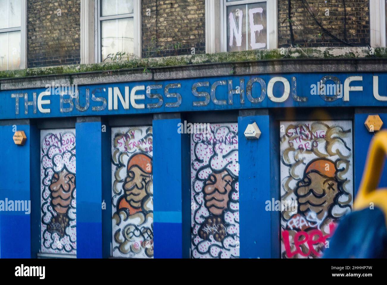 Rundown facade in Shoreditch advertising a Business school, London ...