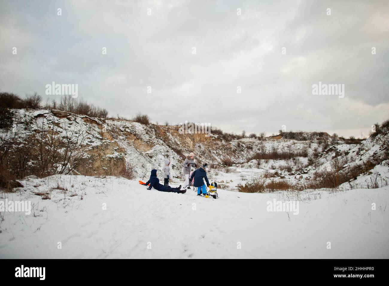Family plays and sleigh rides in winter outdoor, mother and children ...