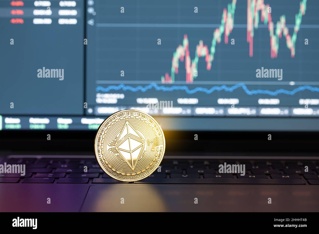 Ethereum coin on laptop and chart on display at background ...