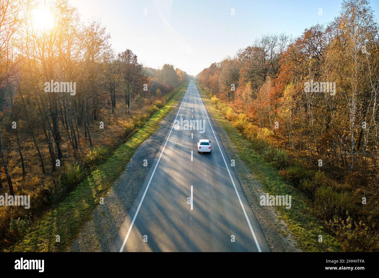 Aerial view of intercity road with blurred fast driving car at sunset ...