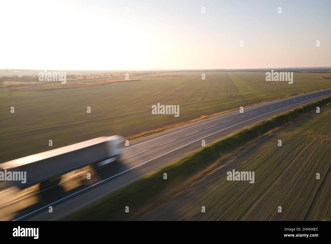 Aerial view of blurred fast moving semi-truck with cargo trailer ...