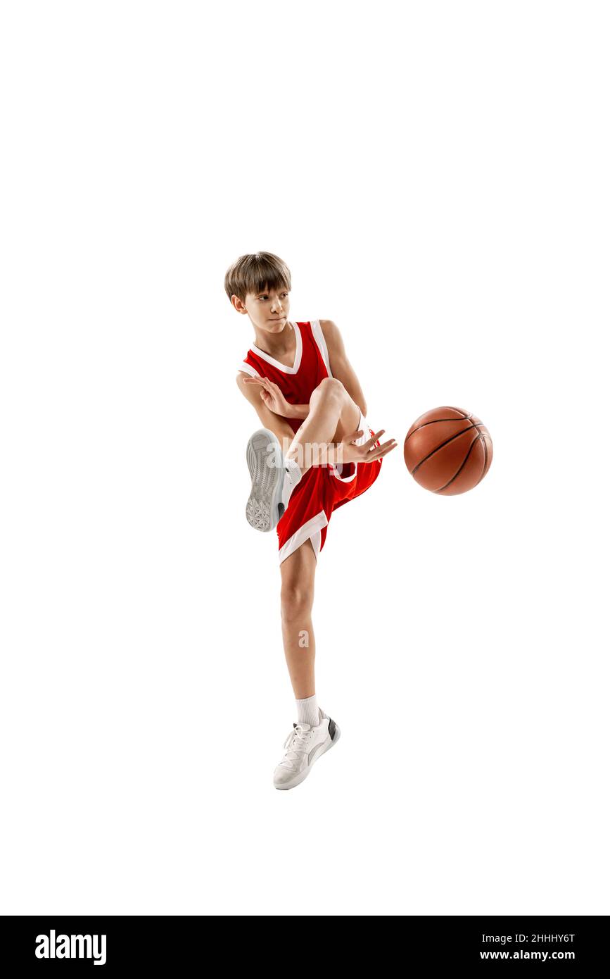 Full-length portrait of young boy, basketball player in red uniform ...