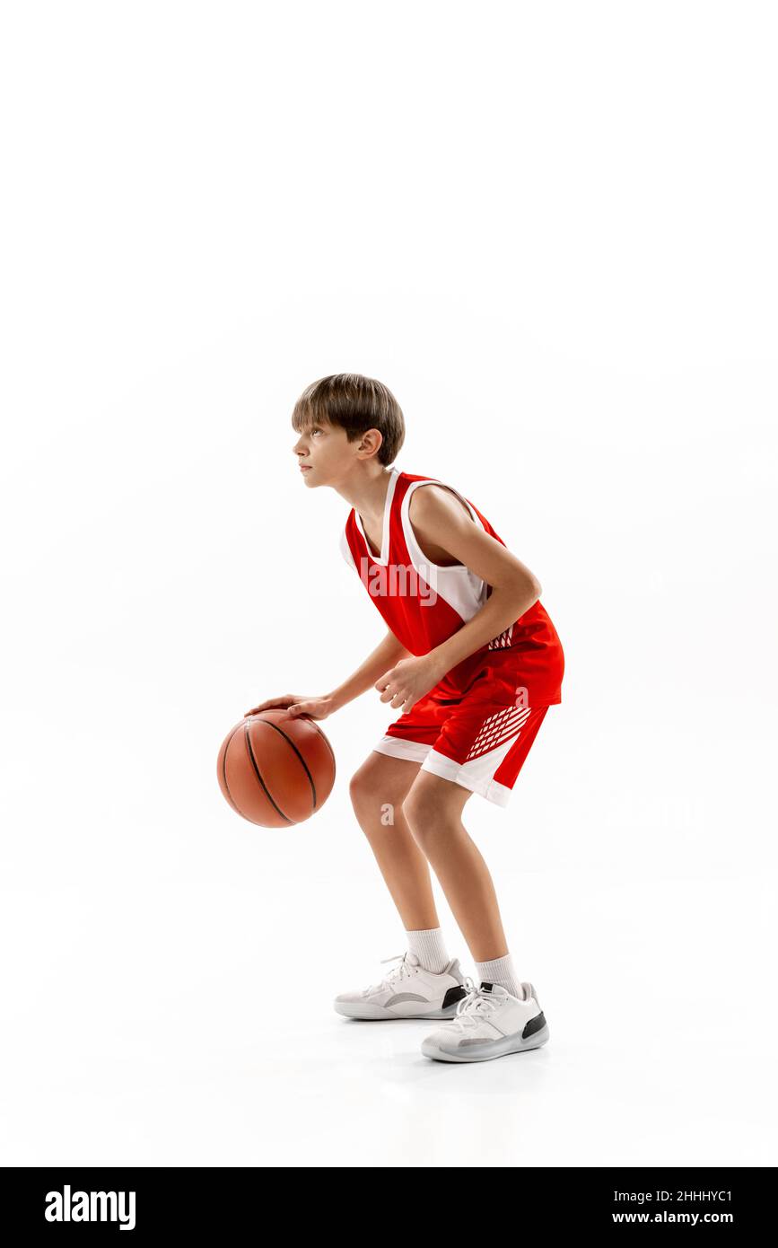 Full-length side view shot of teen boy, basketball player preparing to ...