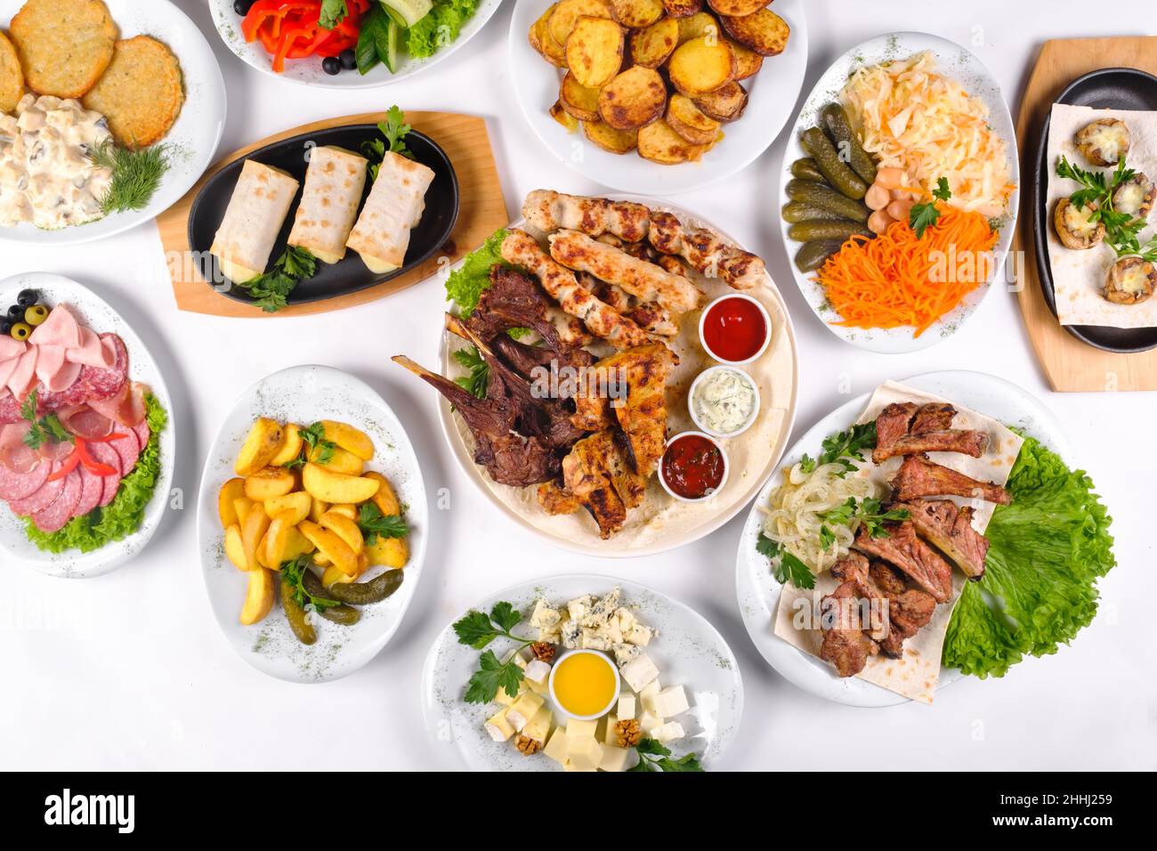 A covered table with many different dinner dishes. Lots of food on a ...