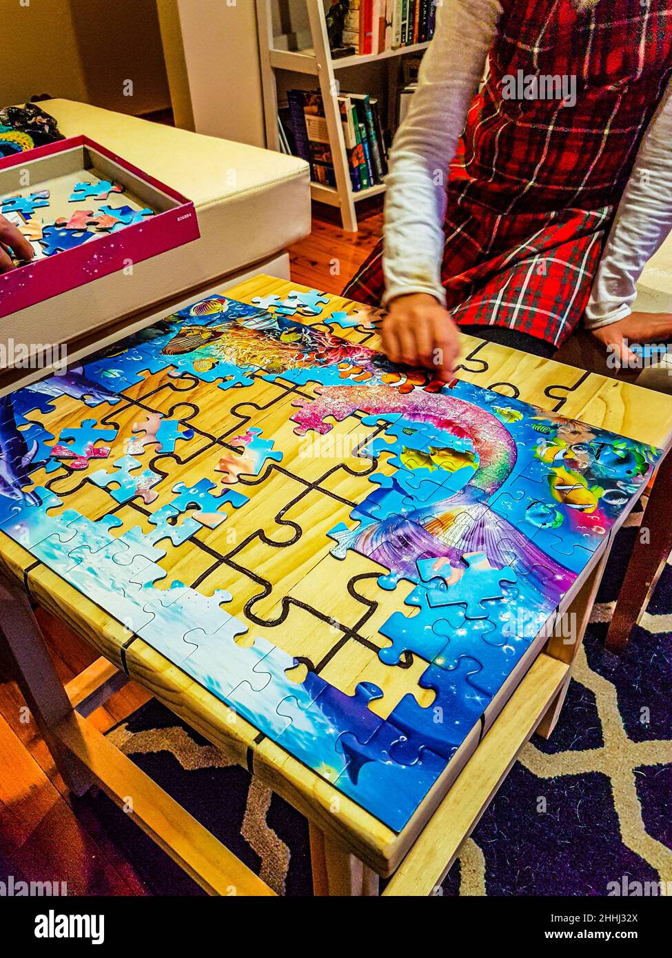 girl doing a jigsaw puzzle on a jigsaw designed table Stock Photo - Alamy
