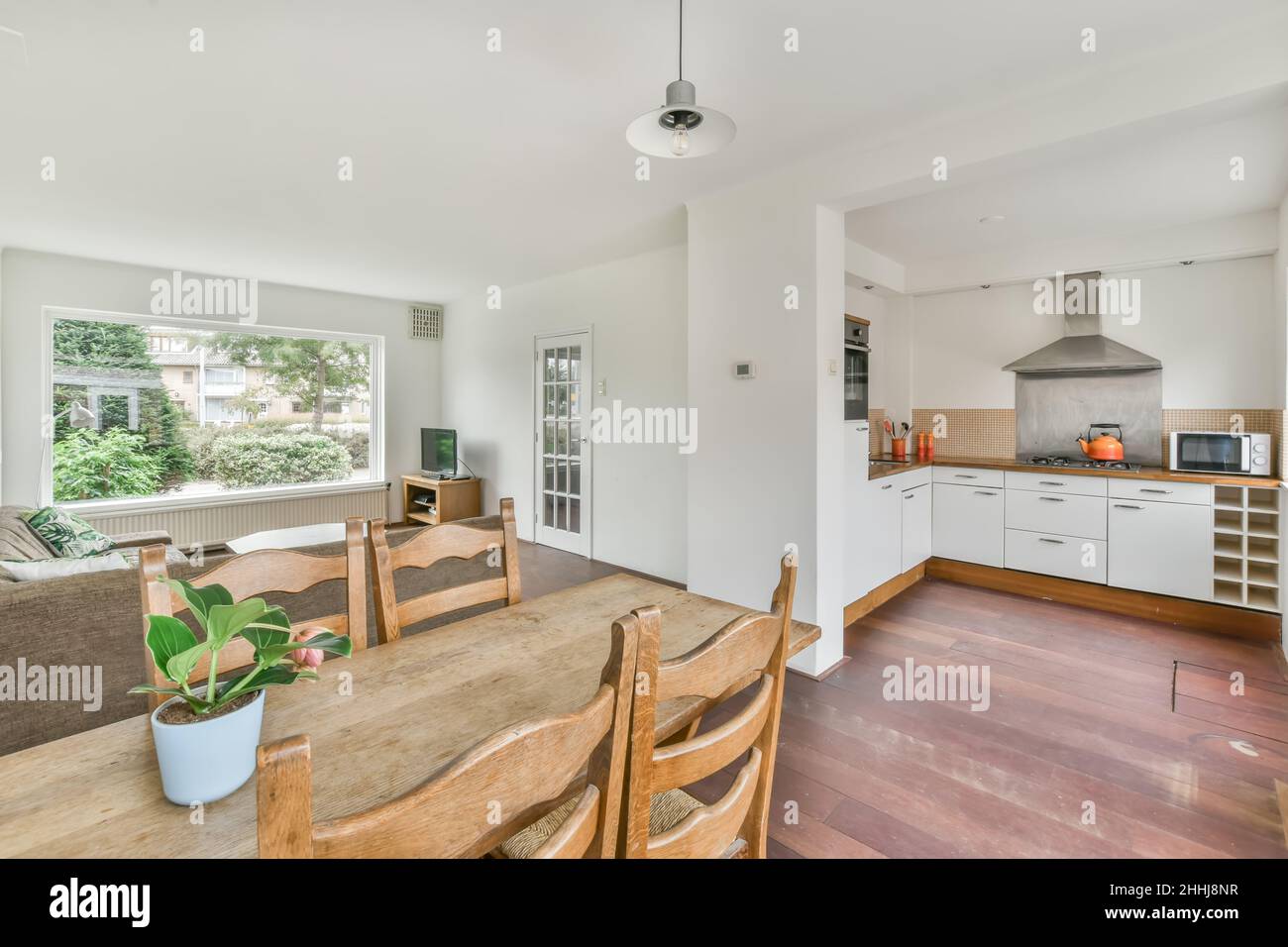 Interior of white wooden kitchen with a set of wooden table and chairs ...