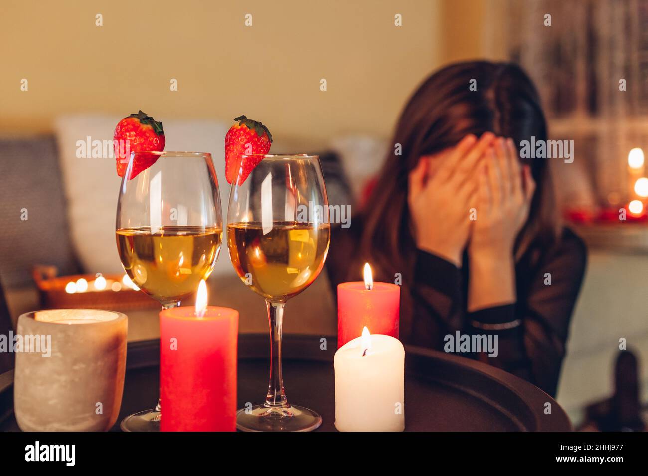Sad woman crying at home by romantic table setting with wine glasses ...