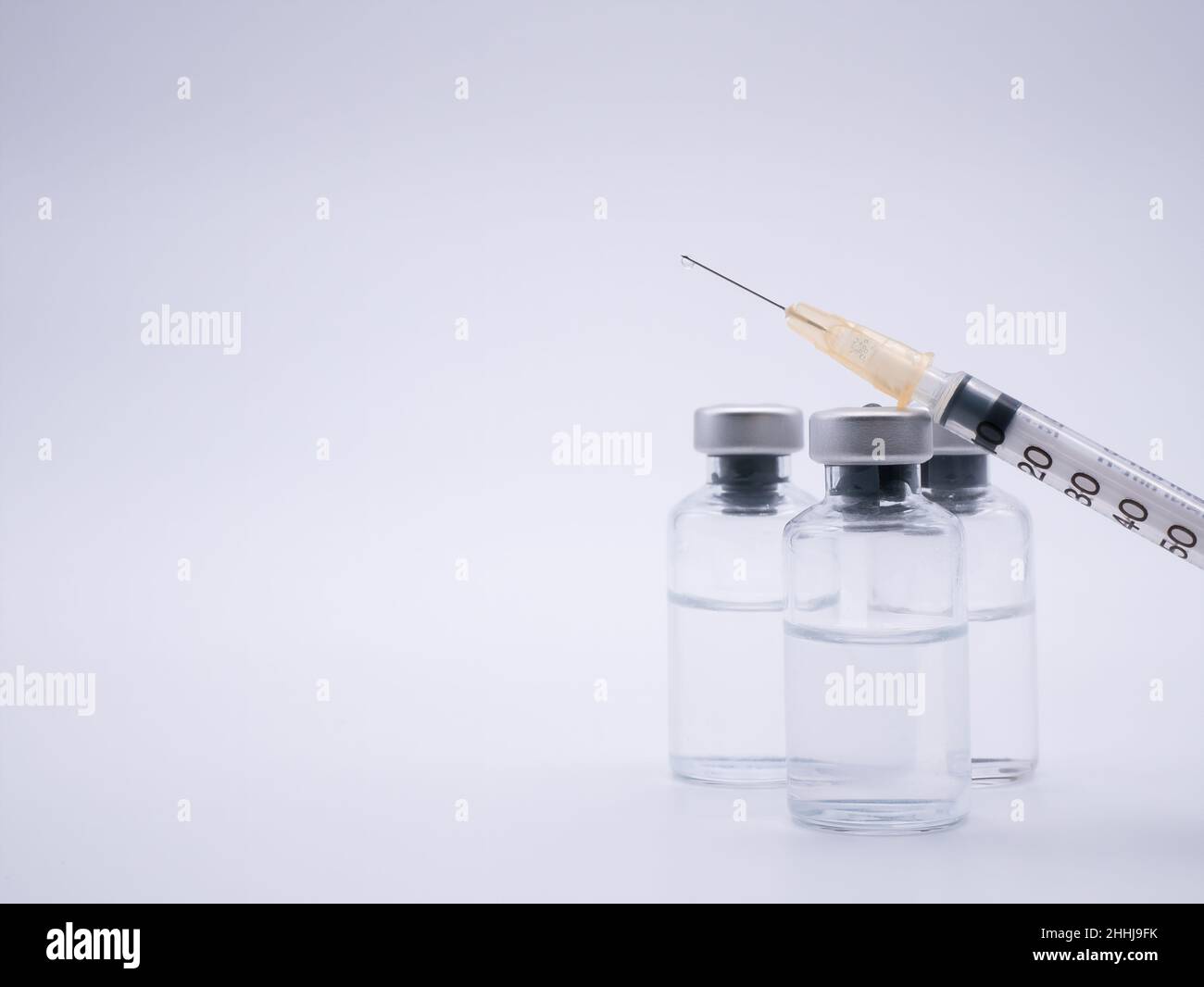 Containers with liquid medicine and syringe isolated on white ...