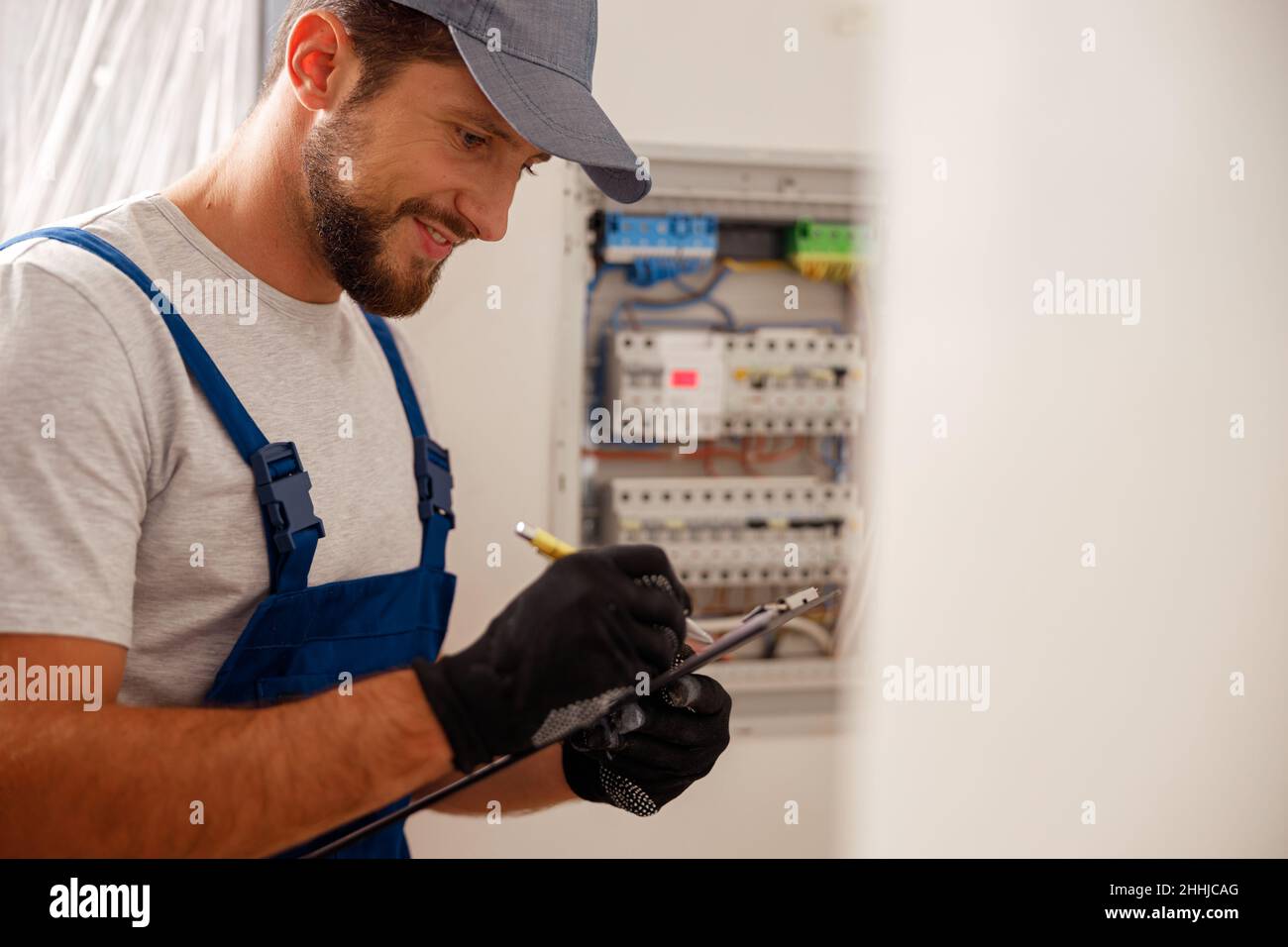 Busy electrical technician writing on a clipboard the data collected on ...