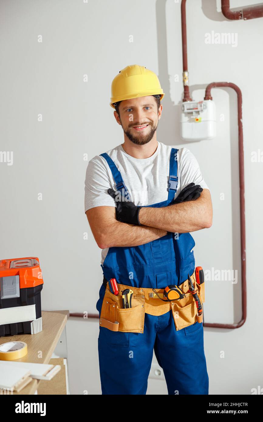 Professional electrician technician in uniform, hard hat and protective ...