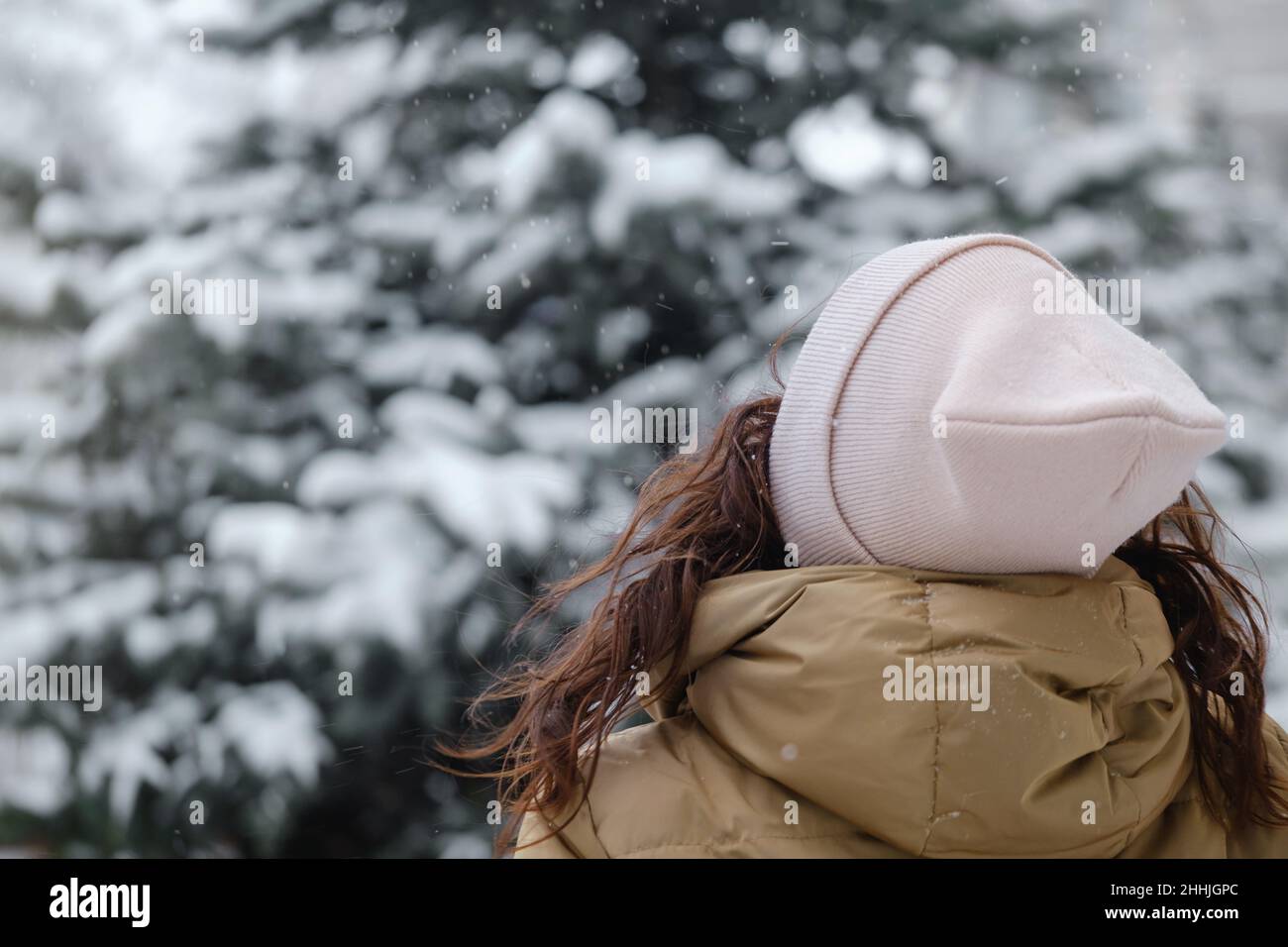 Happy middle age woman catching snowflakes in the city outdoors ...
