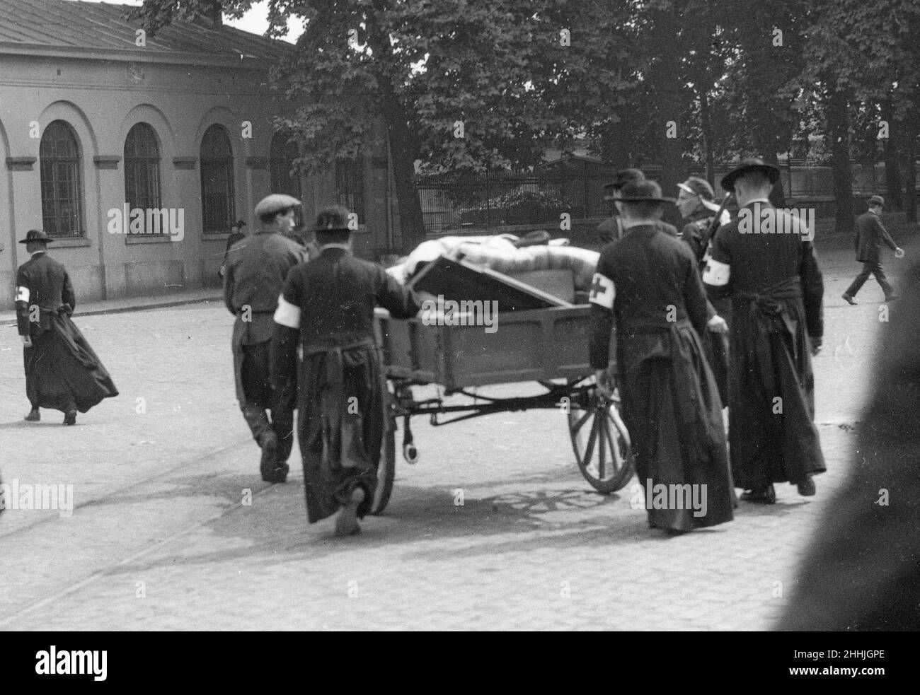 Red Cross priests conveying wounded on cart to hospital Circa August ...